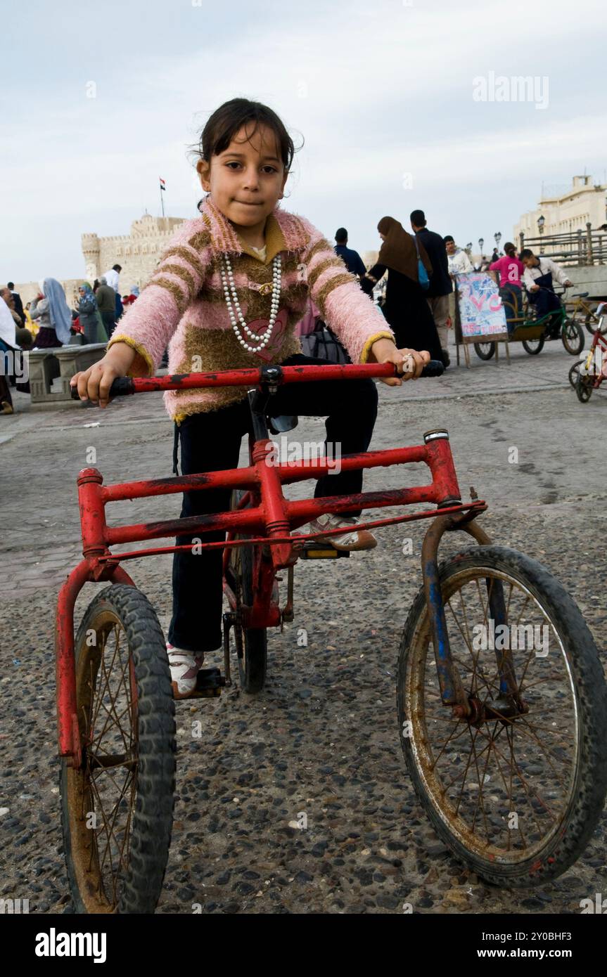 An Egyptian girl riding a funny tricycle in Alexandria, Egypt Stock ...