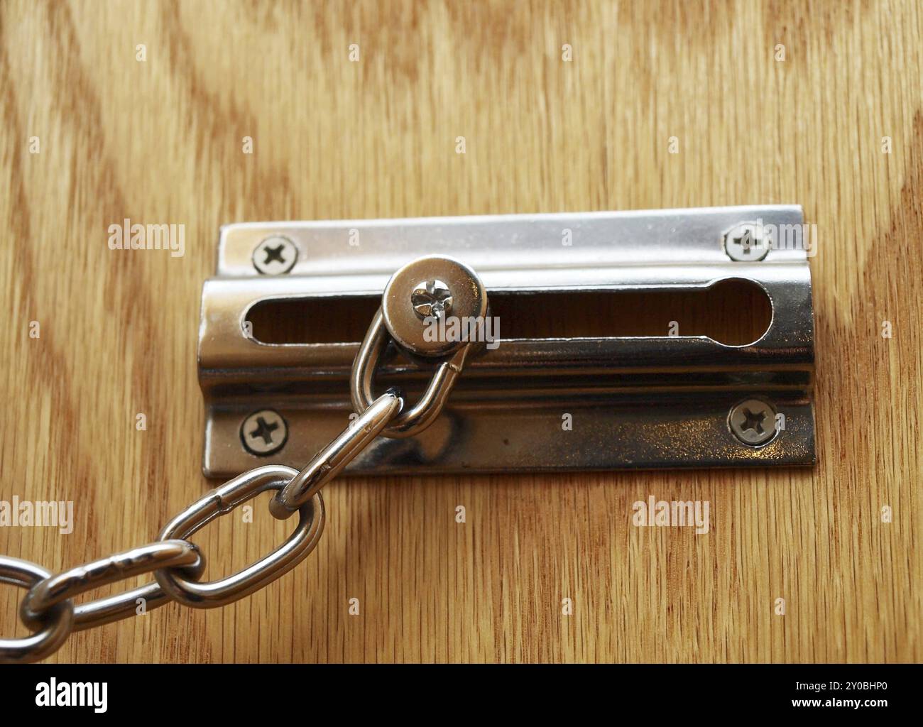Steel door chain on wooden door, locked Stock Photo - Alamy