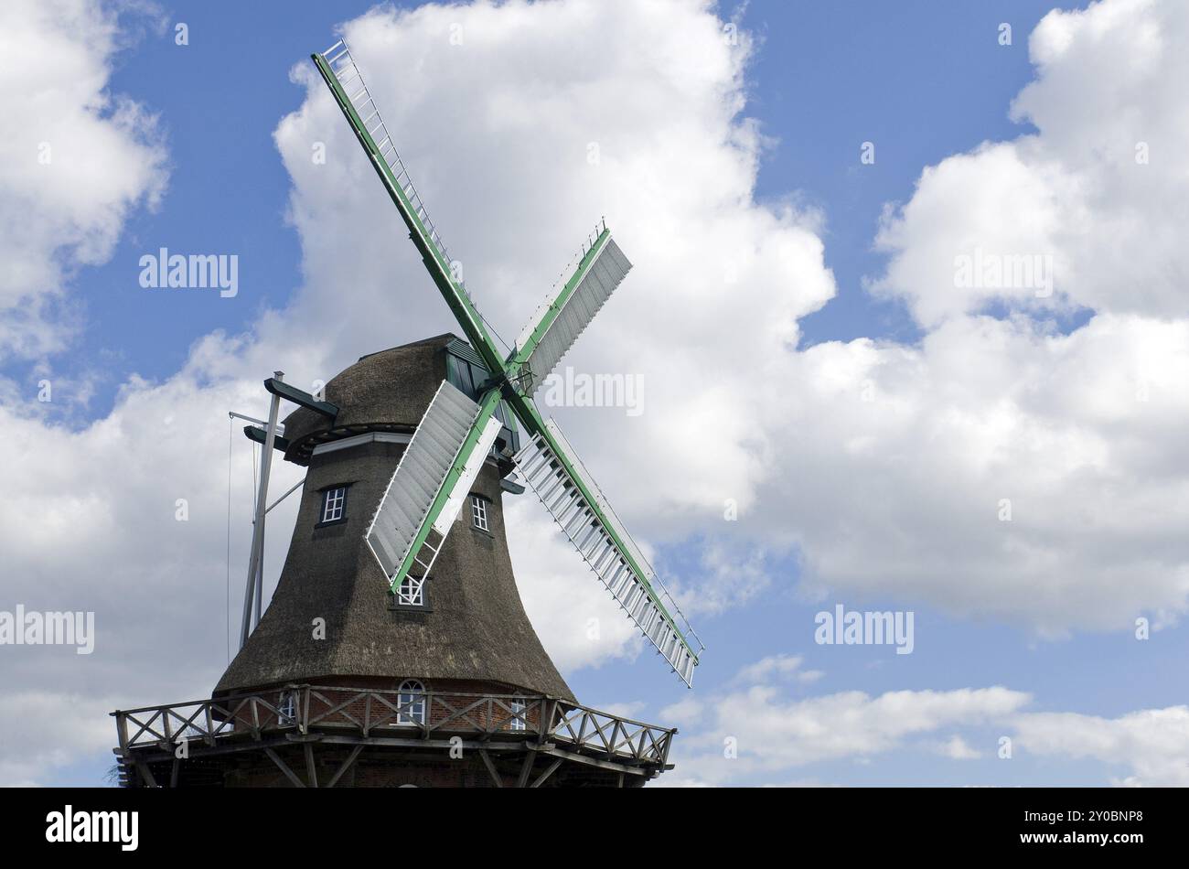 Windmill in front of blue sky and white clouds Stock Photo - Alamy