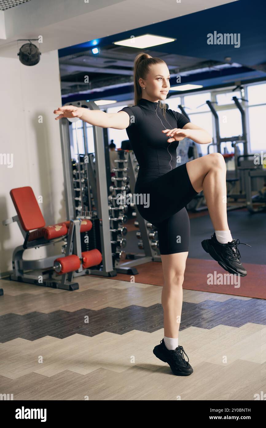 Female athlete performs exercise in modern gym during morning workout ...