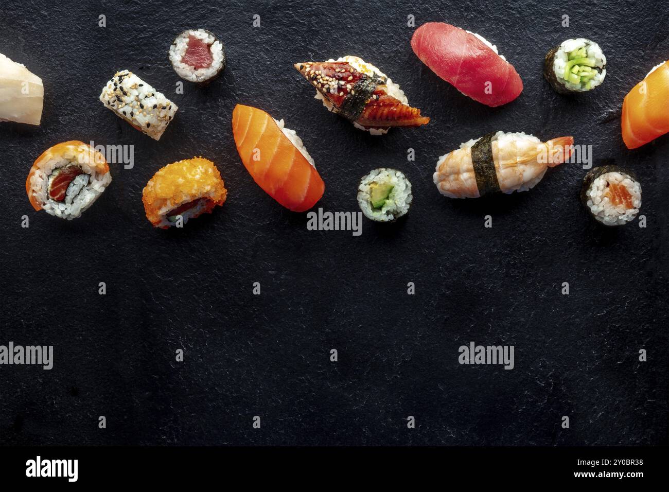 Sushi, shot from the top. Rolls, maki, nigiri on a black slate background, Japanese food. Salmon ...