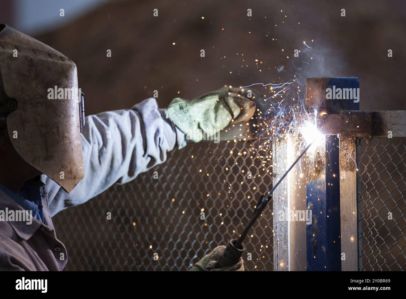 Heavy industry welder worker in protective mask hand holding arc ...
