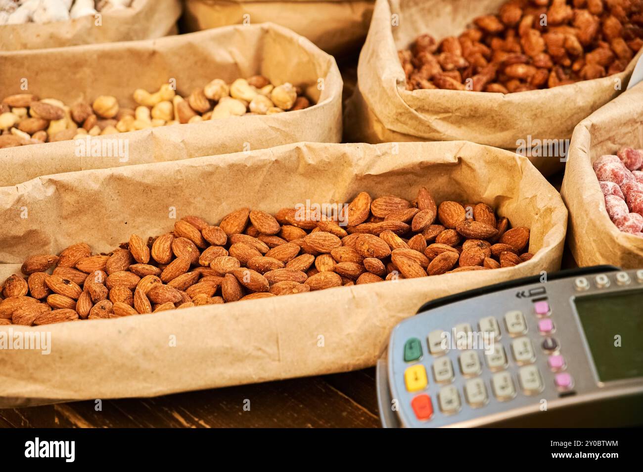Variety of Nuts in Paper Bags at Market Stall and payment terminal ...