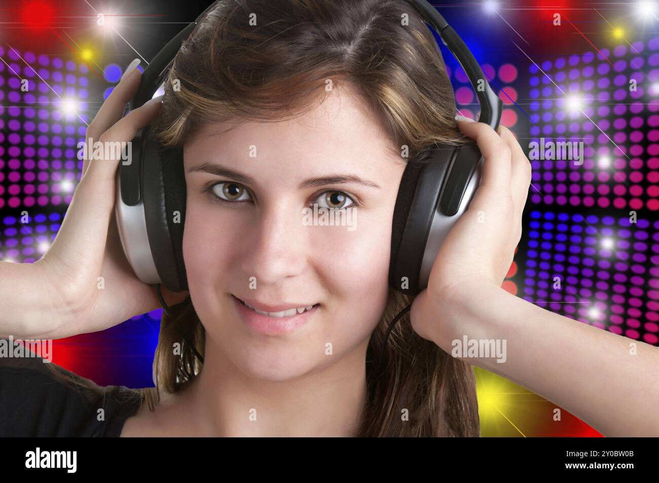 Young woman listening to music through her headphones, isolated in a ...