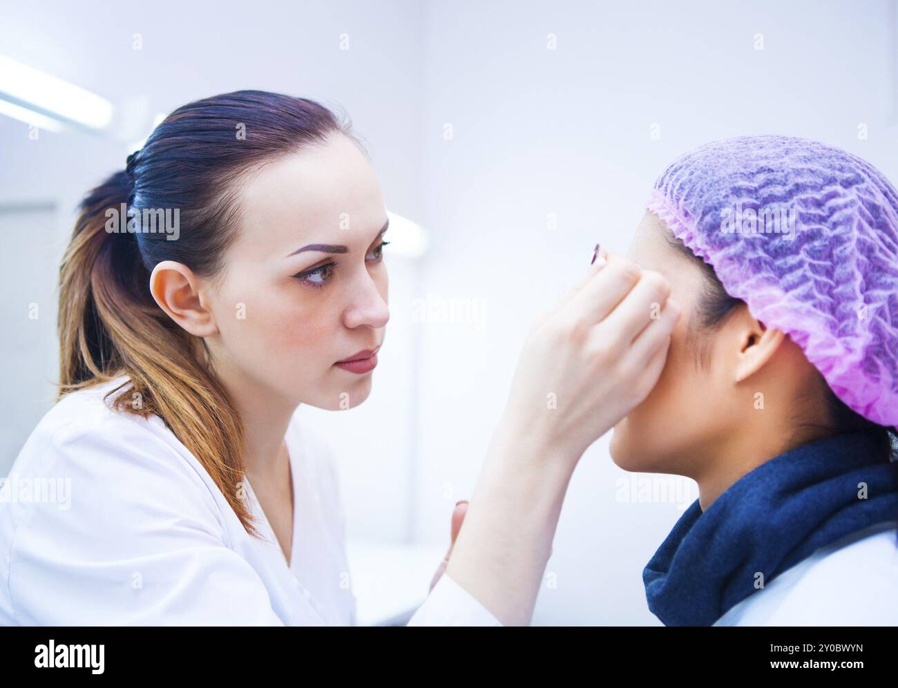Doctor making face treatment to young beautiful asian woman in spa ...