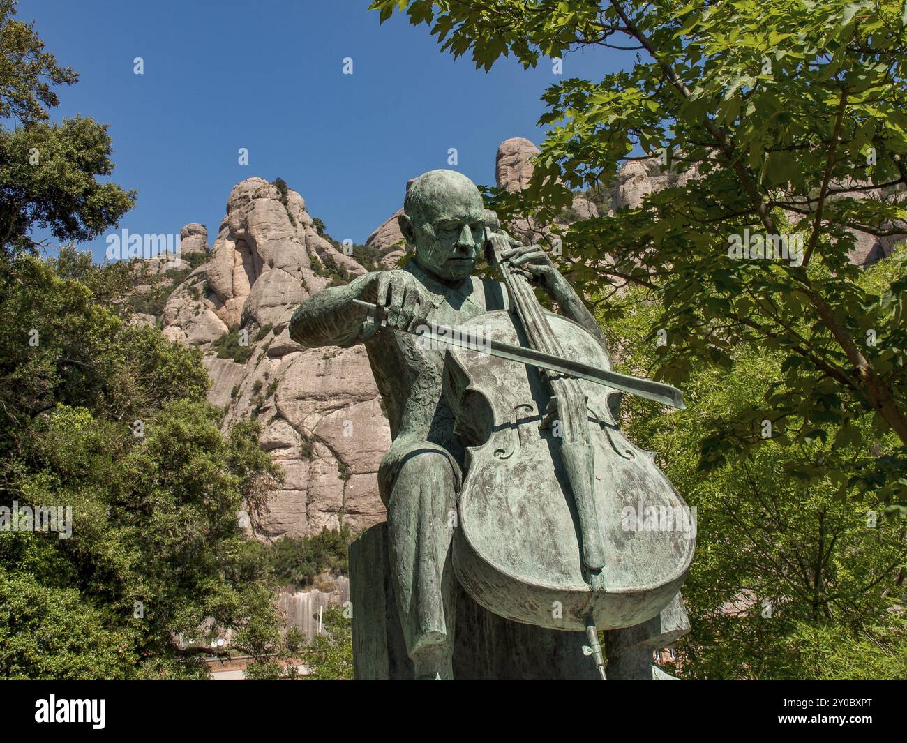 A statue of a cellist in front of a spectacular rocky landscape and ...