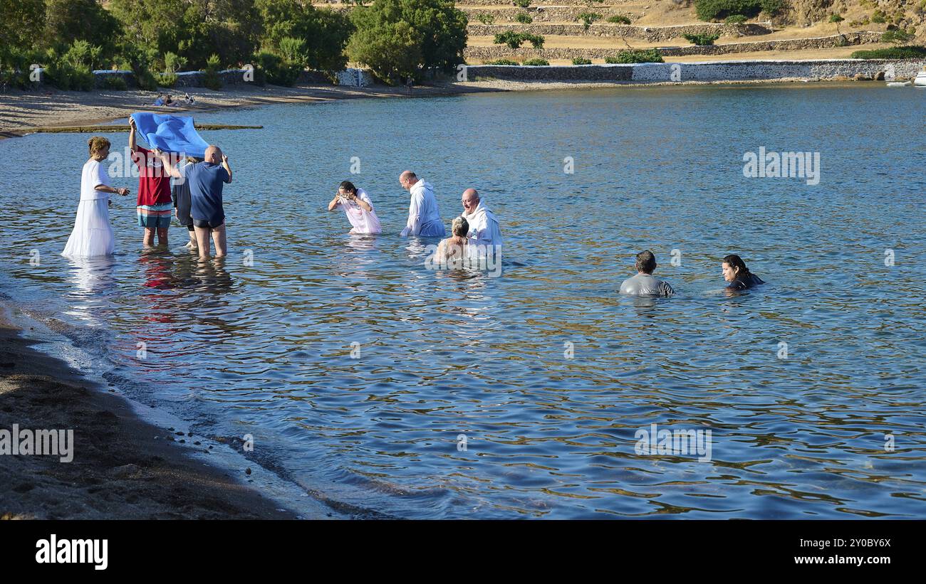 Men in white clothes and swimming costumes performing a ritual ceremony ...