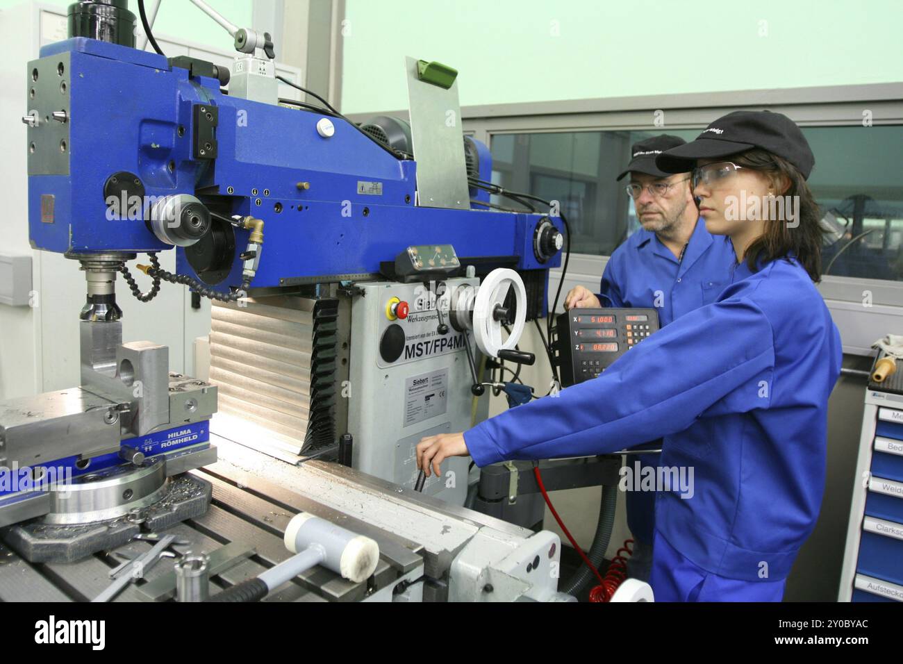 Young woman learning at a lathe, toolmaker, milling cutter, lathe ...