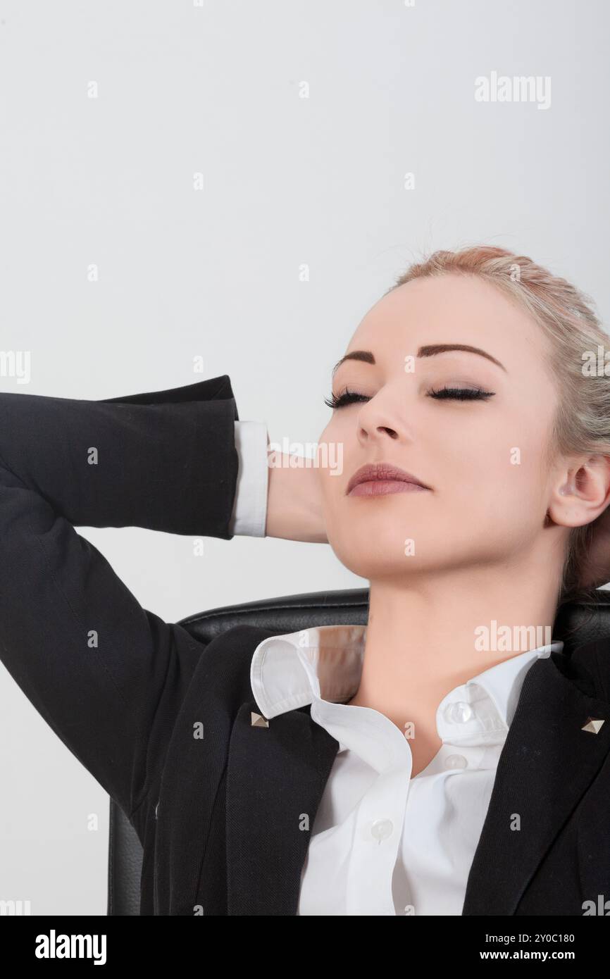 Businesswoman taking a break from work, relaxing with eyes closed and ...