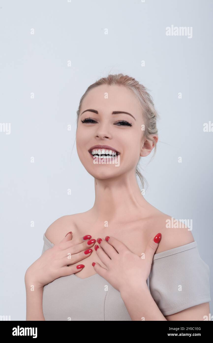 Attractive young woman with red nail polish is holding her hands to her ...