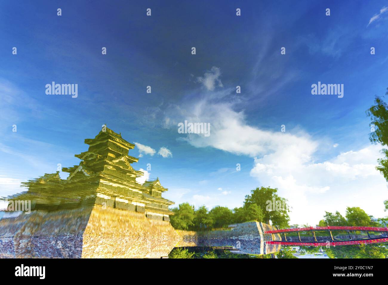 Moat water surface mirror image reflection of Matsumoto Castle keep ...