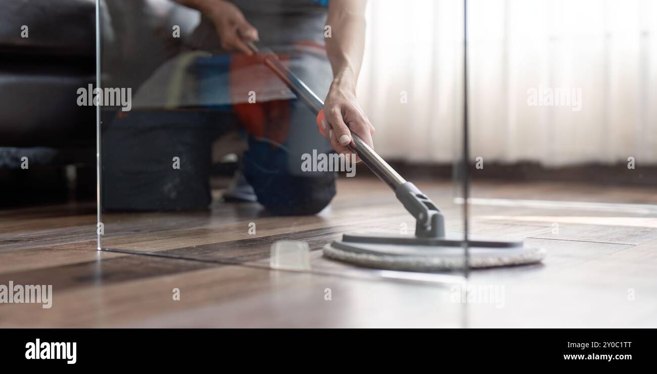 Housekeeper mopping floor under glass table for cleanliness Stock Photo ...