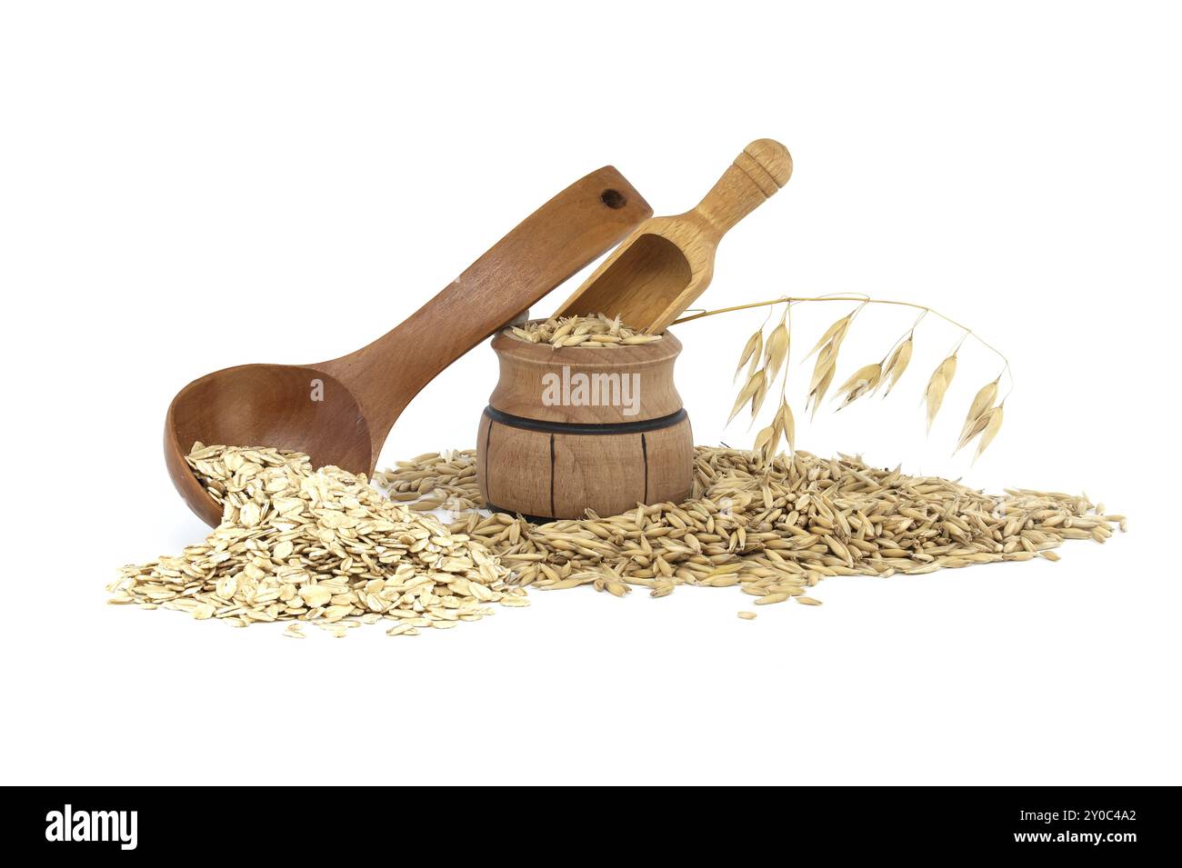 Oat grains with hulls or husks spilling from a wooden barrel and oats ...