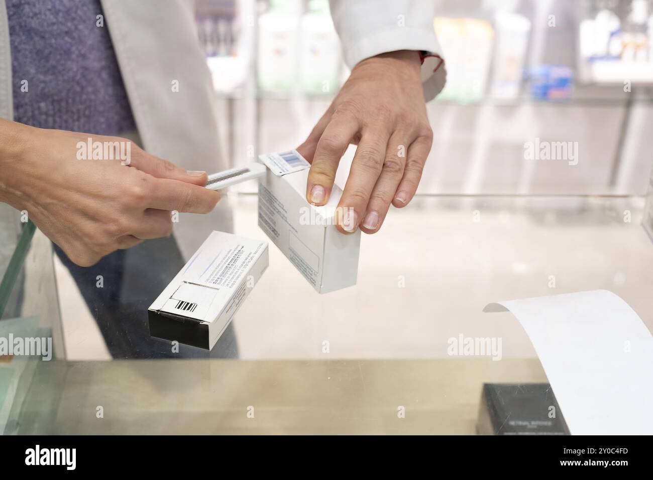 A pharmacist cuts out the barcode on a medication to control inventory ...