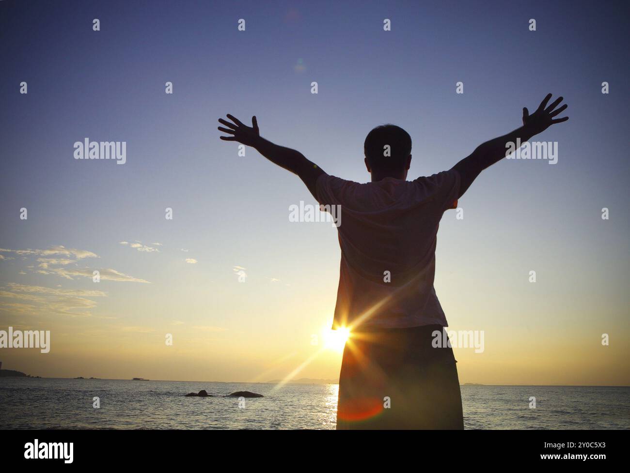 Man backlit raises arms sky hi-res stock photography and images - Alamy