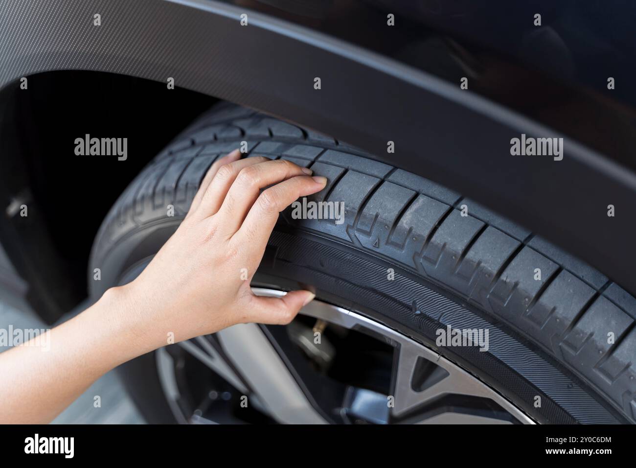 Hand woman checking air pressure air car tire. Close-up of ...