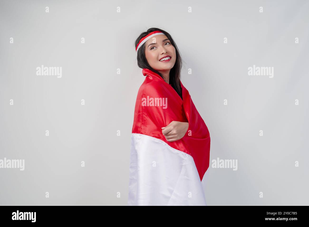 Smiling young Asian woman with Indonesian flag draped over her ...