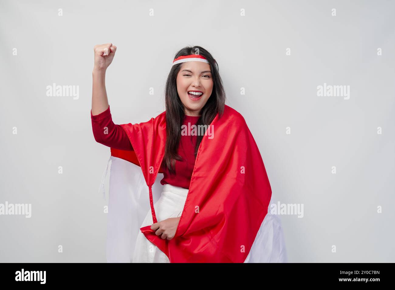Happy young Asian woman with Indonesia flag draped over her shoulders ...