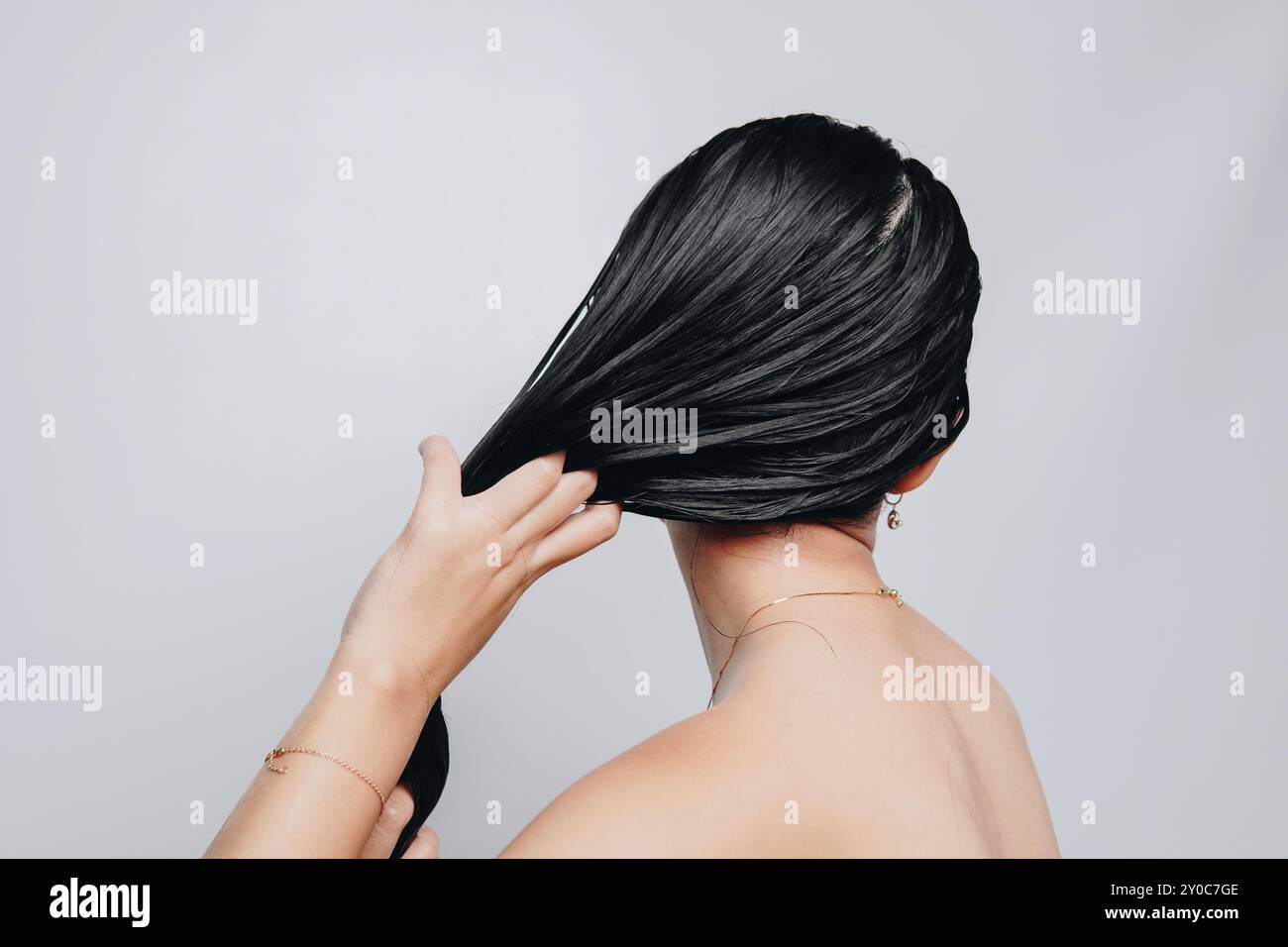 Back portrait of beautiful young Asian woman with long hair is getting ...