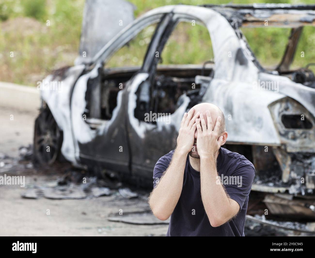 Crying upset caucasian man at road wreck accident or arson fire burnt ...