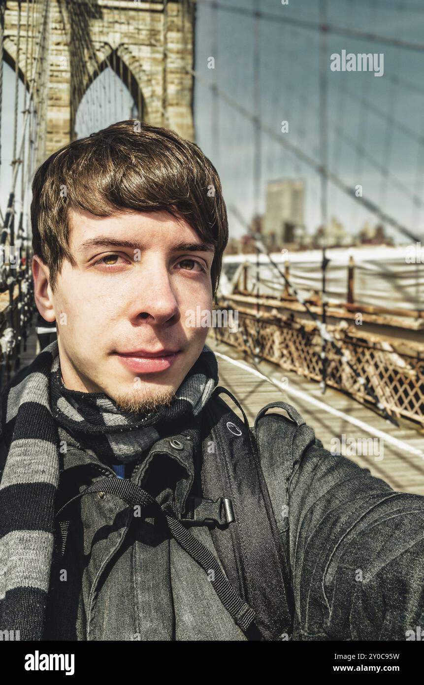 Young adult man with brown hair and beard taking a selfie, looking at ...