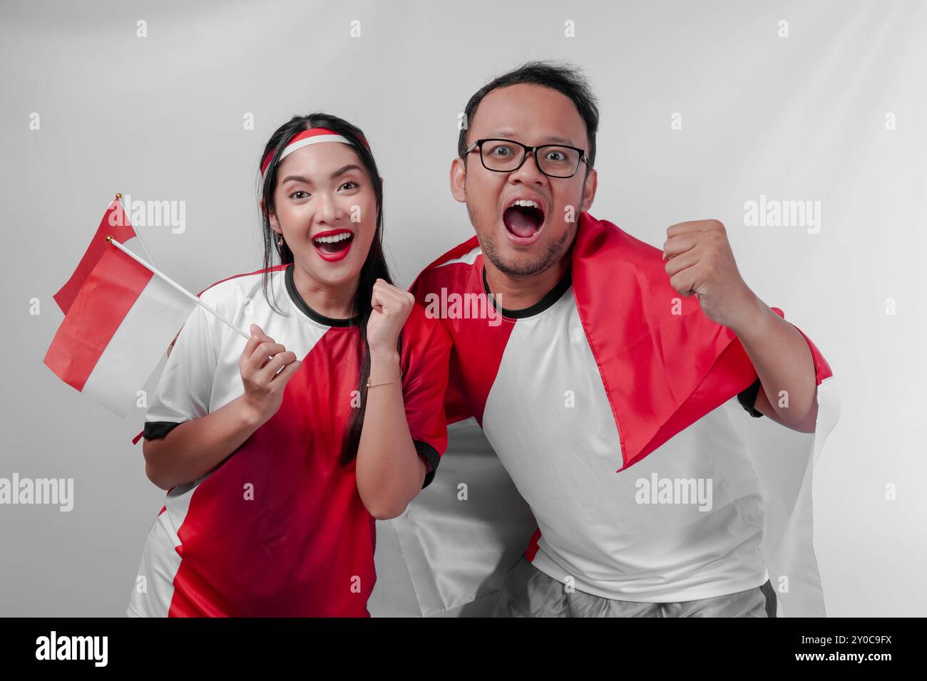 Young Indonesian couple is holding country flags, feeling excited and ...