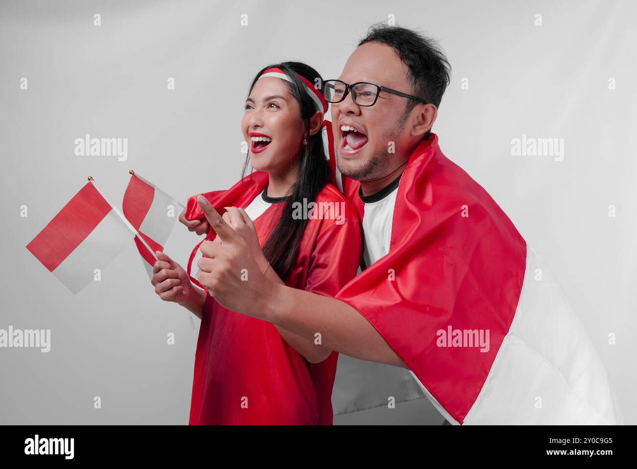 Young Indonesian couple is holding country flags, feeling excited and ...