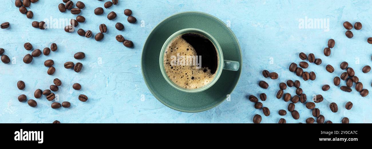 Coffee cup and coffee beans panorama, overhead flat lay shot on a blue ...