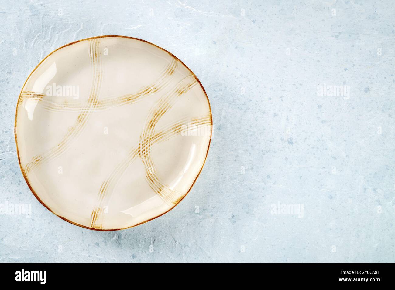 An empty plate with a gold rim, overhead flat lay shot on a slate ...