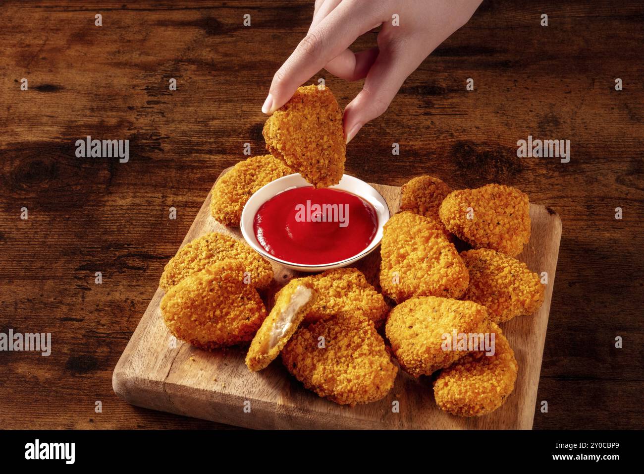 Chicken nugget dipped in ketchup. A crispy snack at a restaurant, a ...