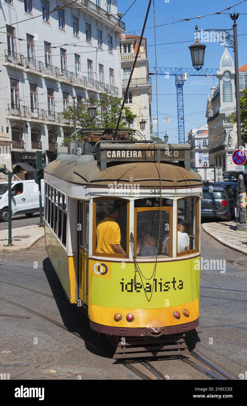 Yellow-green tram bends around a curve through the city, Tram, Line 28 ...