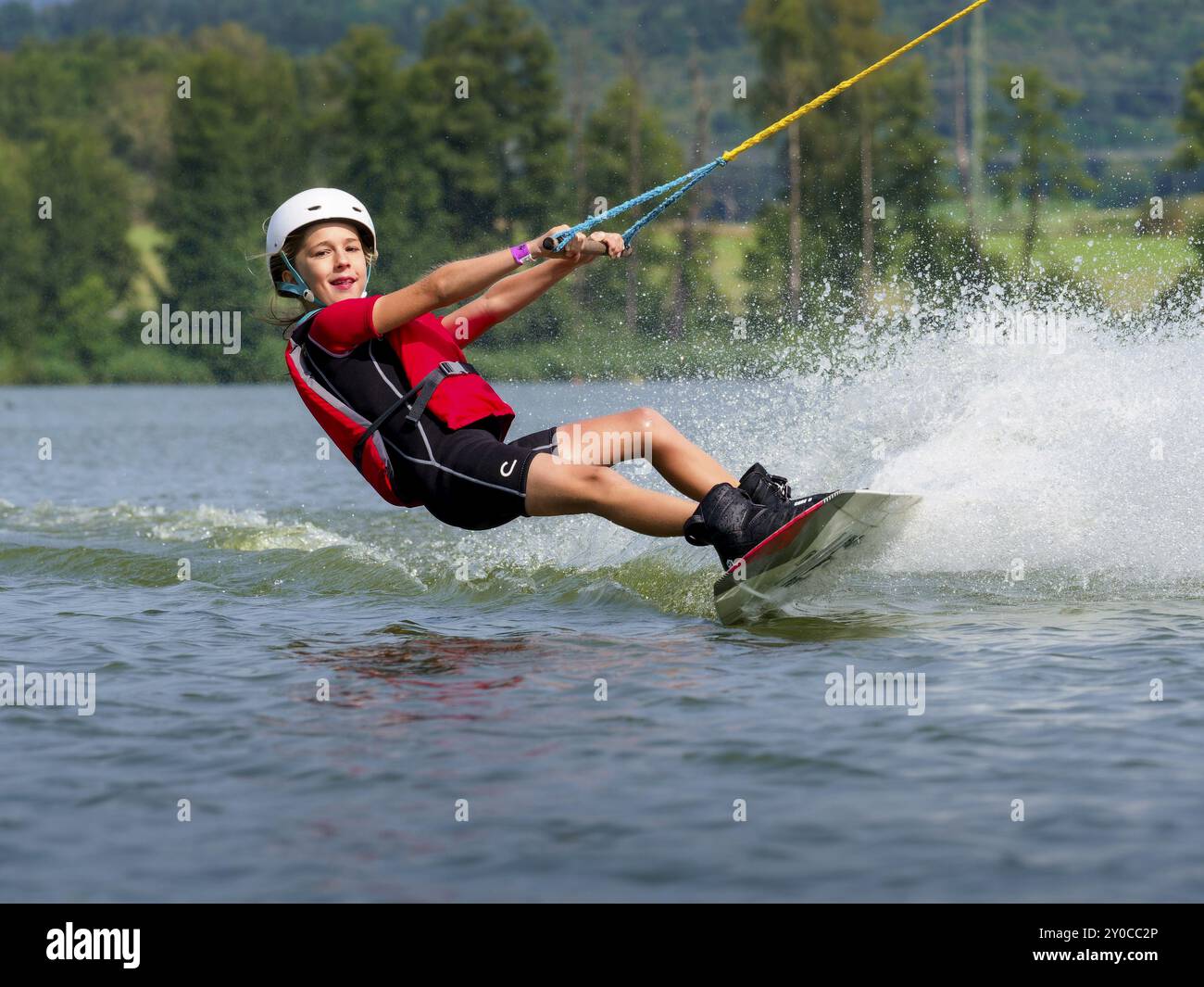 Boy or girl, happy summer holiday with wakeboard, water splashes, red ...