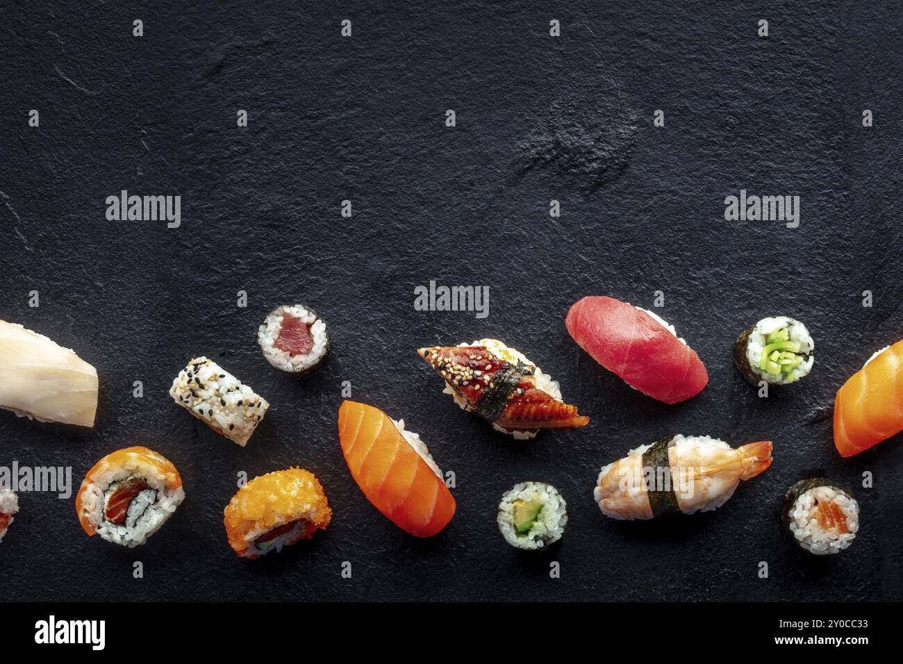 Sushi, shot from above. Rolls, maki, nigiri on a black slate background ...