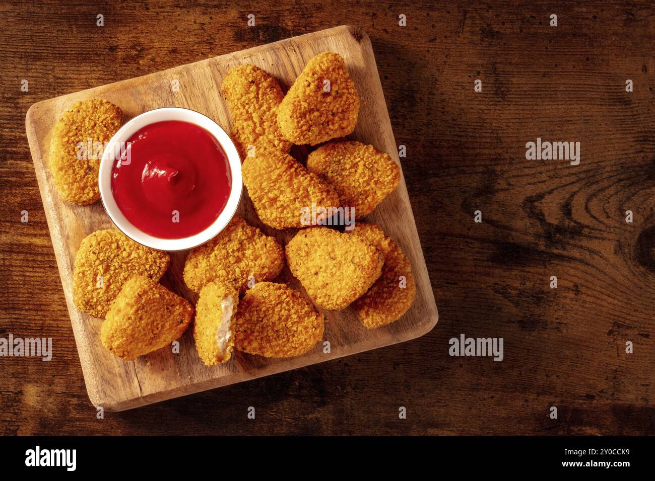Chicken nuggets with ketchup on a dark wooden background, shot from ...