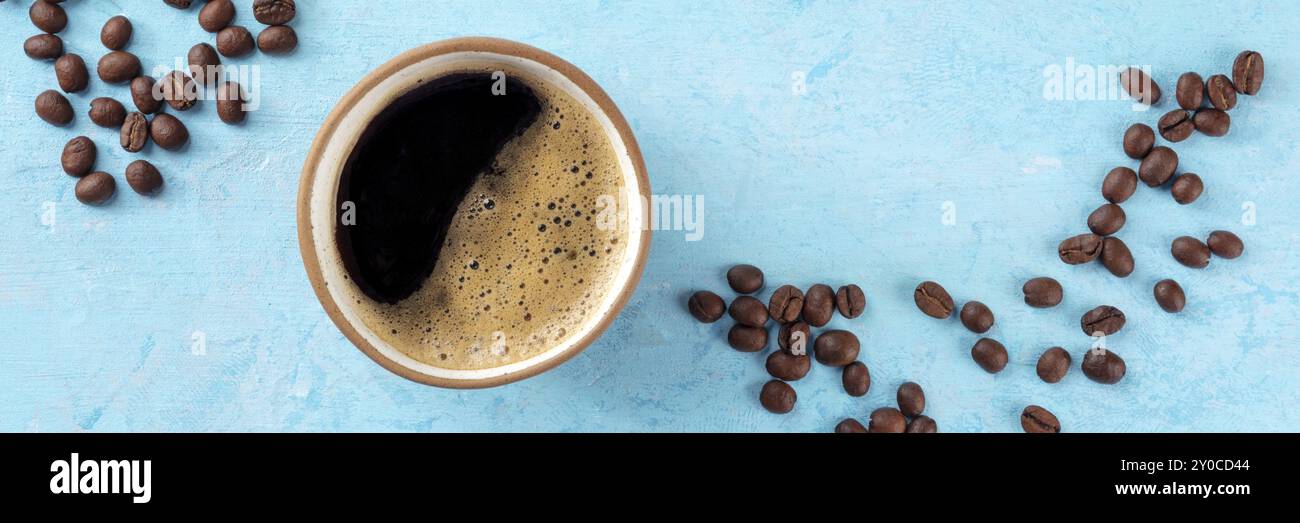 Coffee cup and beans panorama, top flat lay shot on a blue background ...