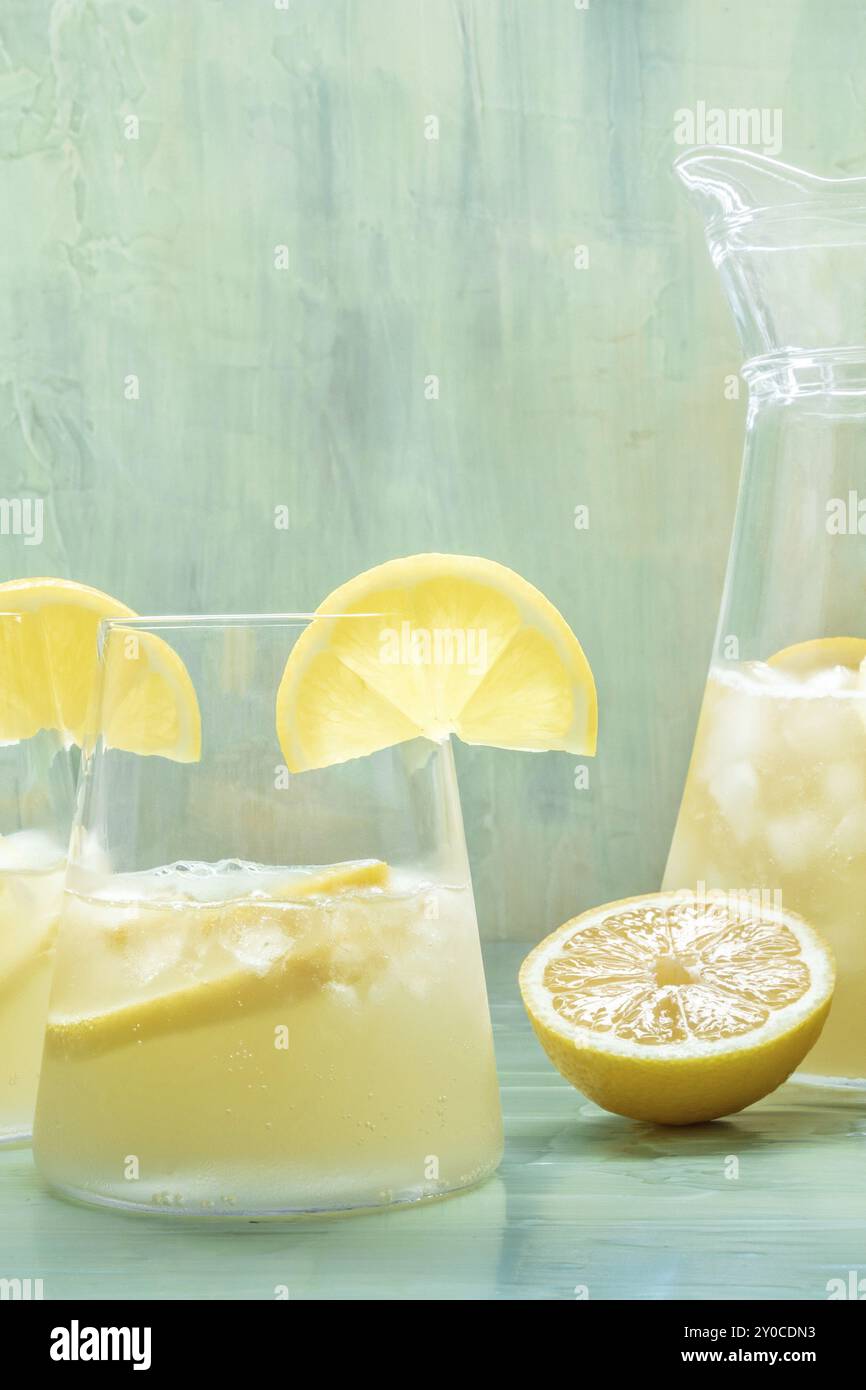 Lemonade. Lemon water drink with ice on a blue background, with copy ...
