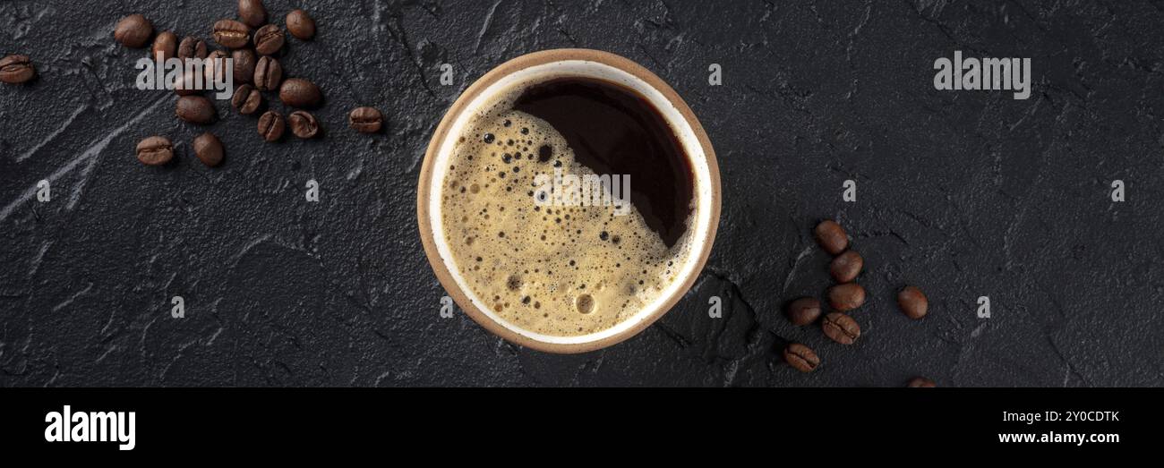 Coffee cup and beans panorama, top flat lay shot on a black stone ...