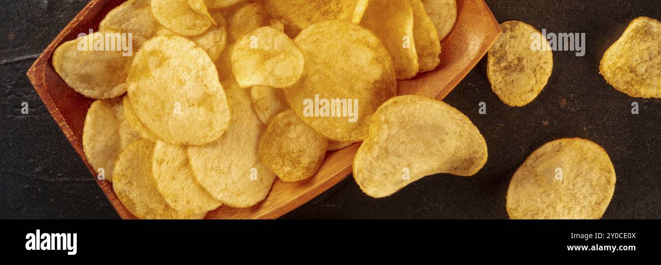 Potato chips or crisps panorama, a salty snack close-up, overhead flat ...