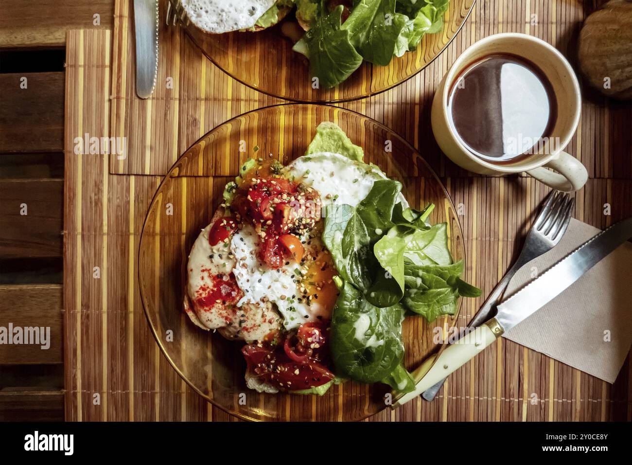 Breakfast at a cafe. Toast with egg, tomato, and spinach, with a cup of ...