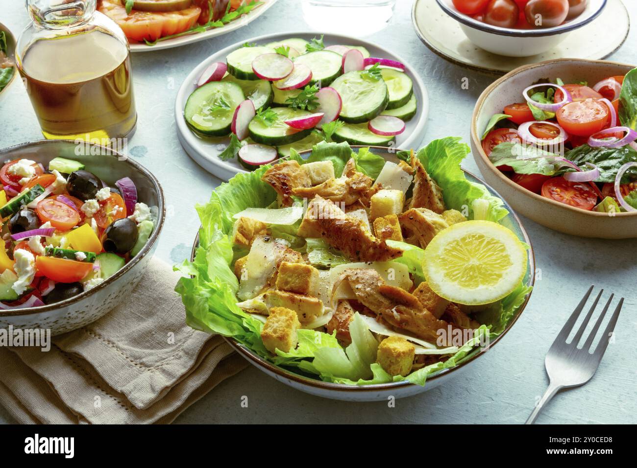 Fresh salads, an assortment. Variety of plates and bowls with green ...