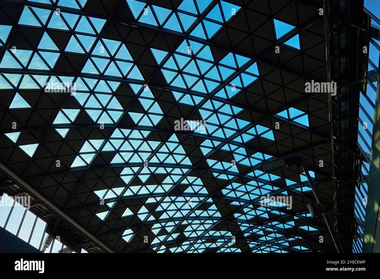 Modern glass ceiling with triangular pattern against blue sky ...