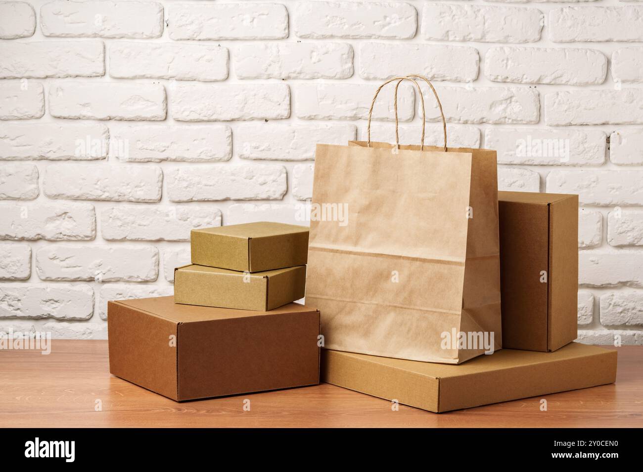 Stacked Cardboard Boxes Against A White Brick Wall Stock Photo - Alamy