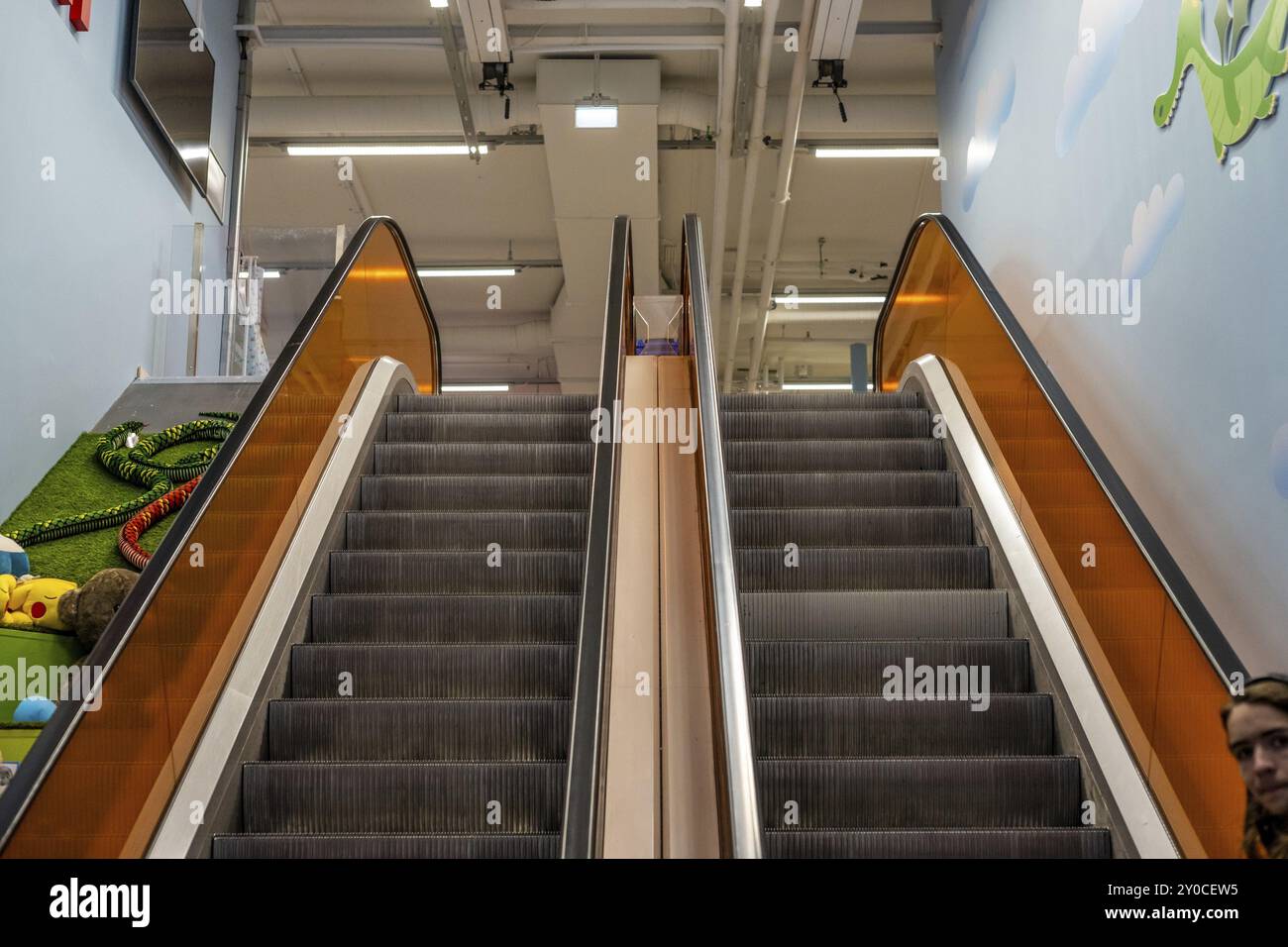 Top of an escalator with orange glass railing inserts Stock Photo - Alamy
