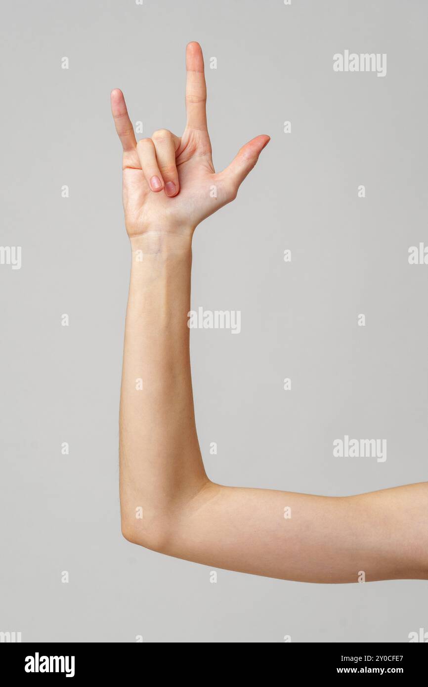 A Woman's Arm Making a Rock On Hand Gesture Stock Photo - Alamy