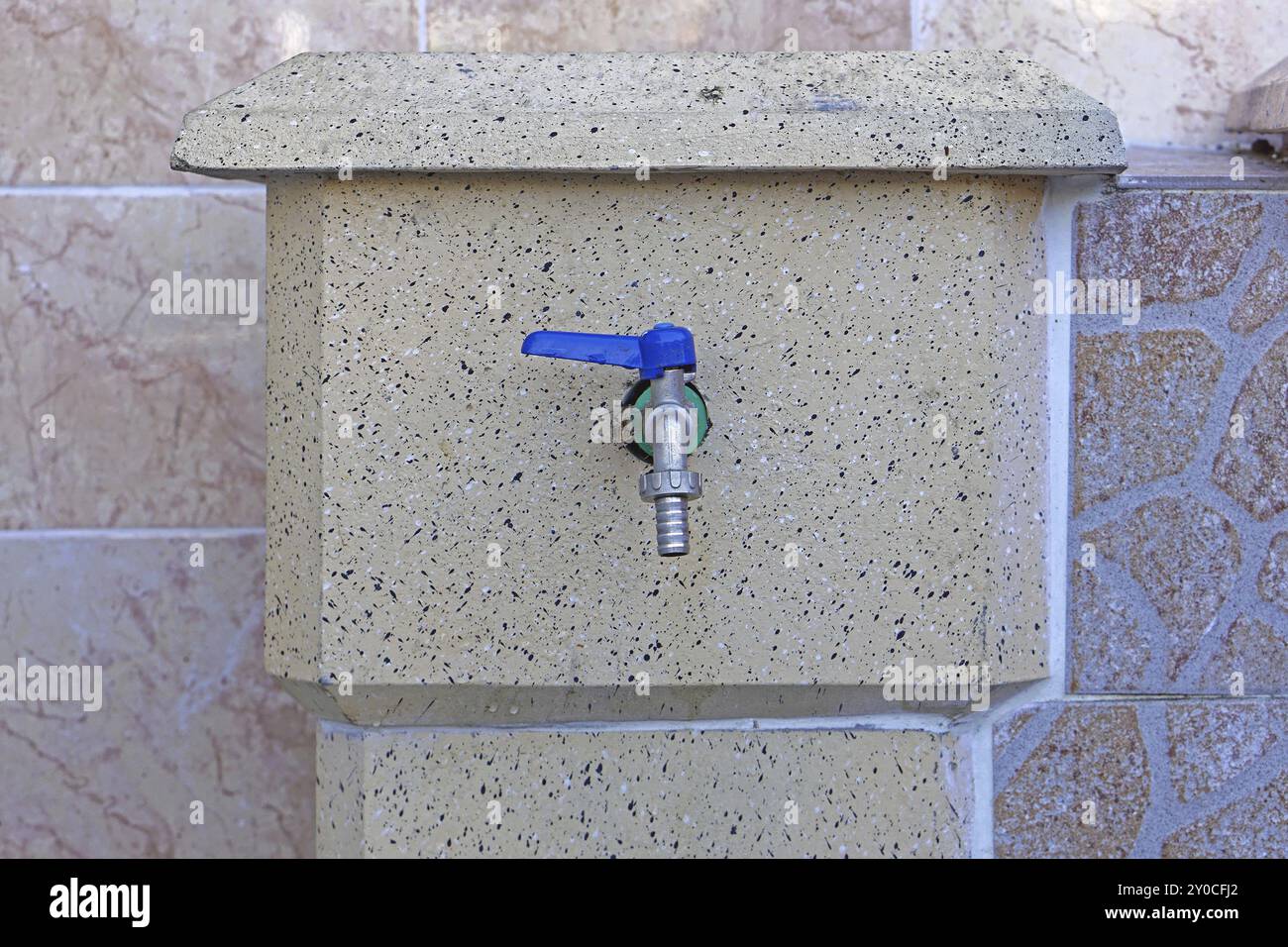 Water faucet with blue handle and hose attachment Stock Photo - Alamy