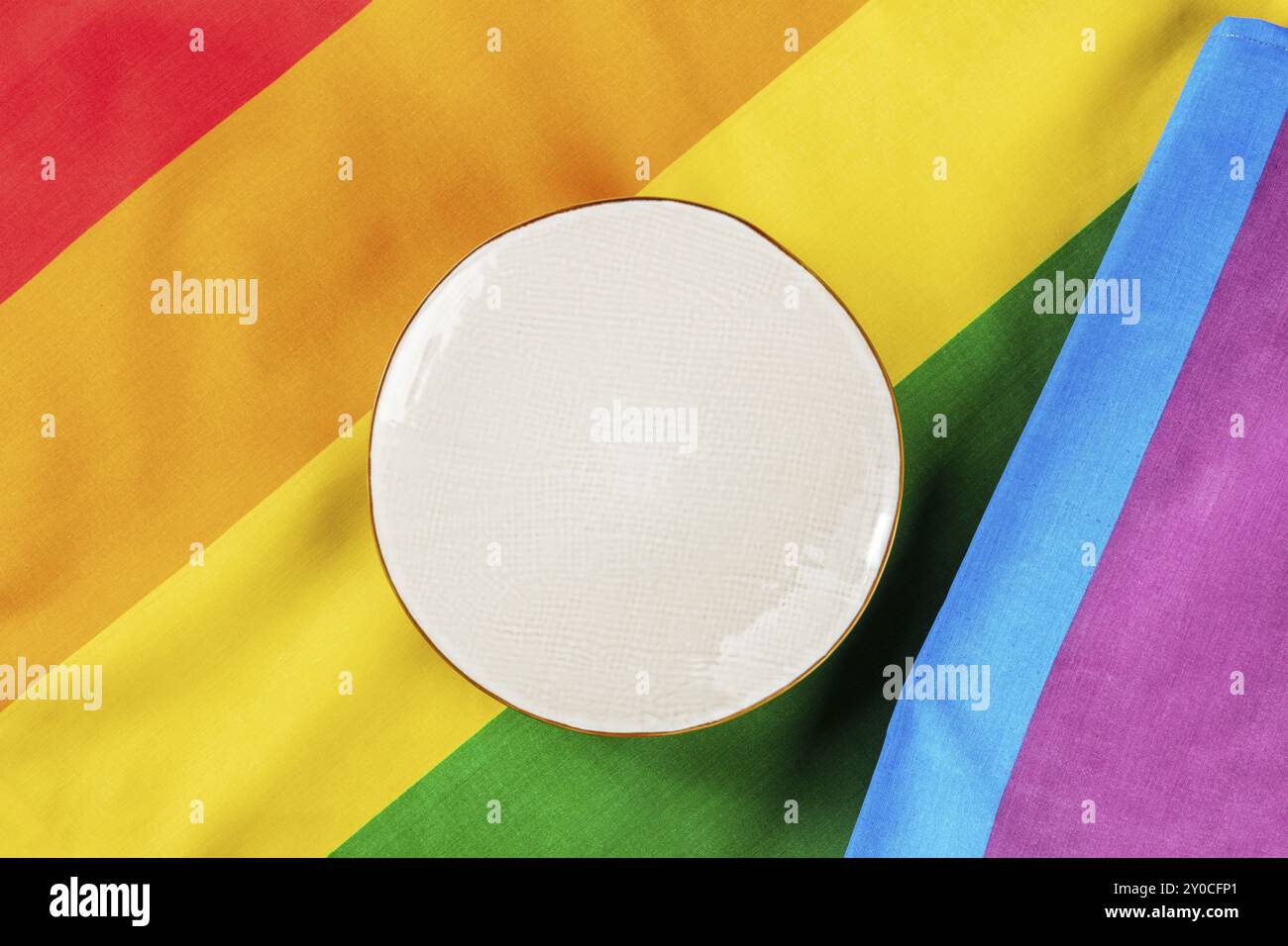 Gay food concept. A plate, overhead flat lay shot on the LGBTQ rainbow ...