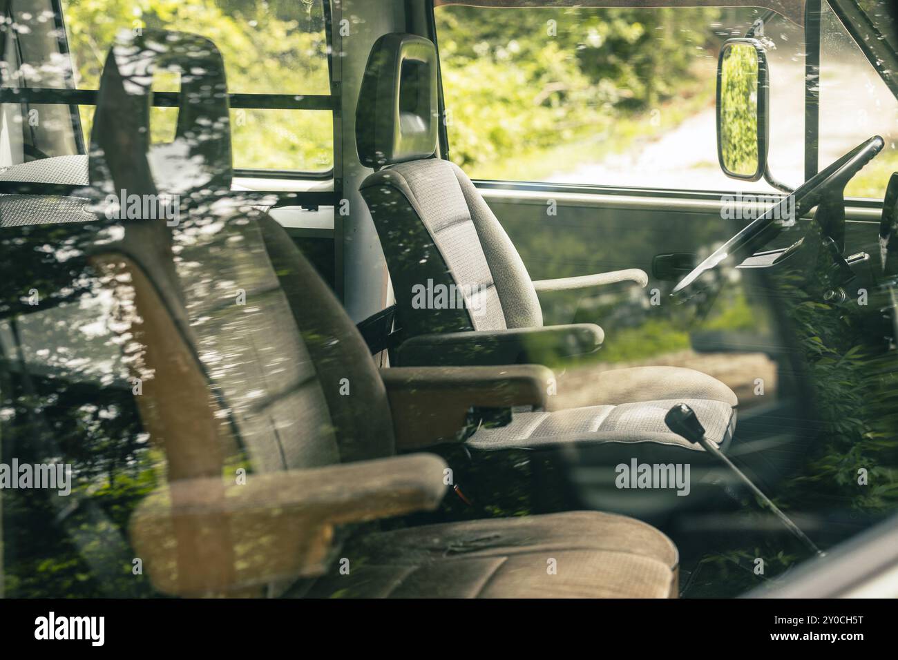 Drivers position of an old vintage van. Big plastic steering wheel and ...