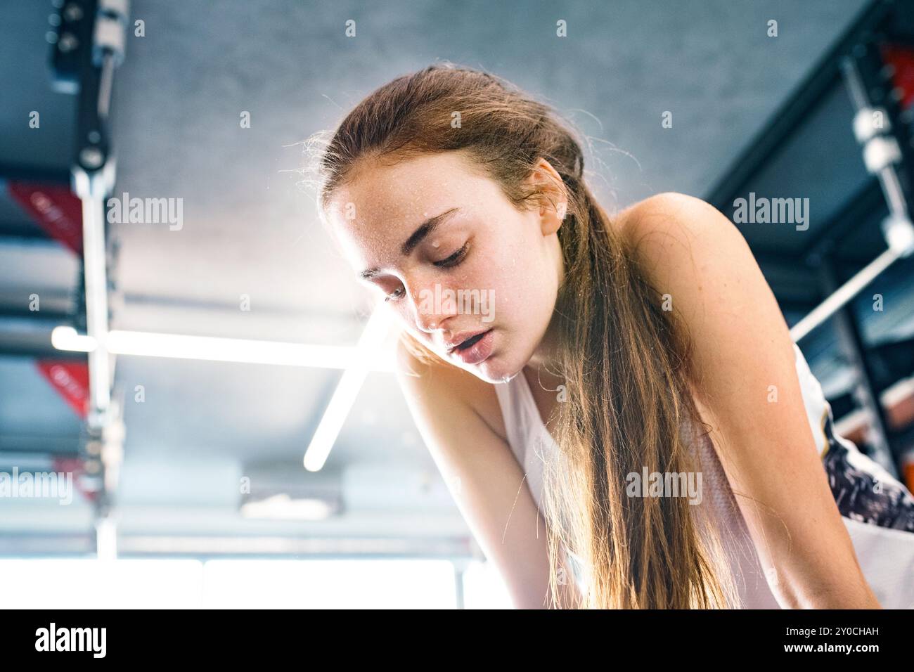 Young fitness girl with sweat on face feeling exhausted after hard ...
