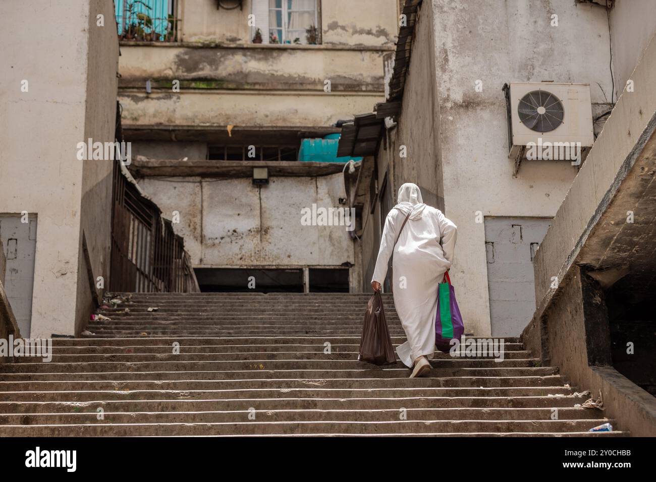 Arab or muslim woman is walking up a long set of stairs in dirty ...