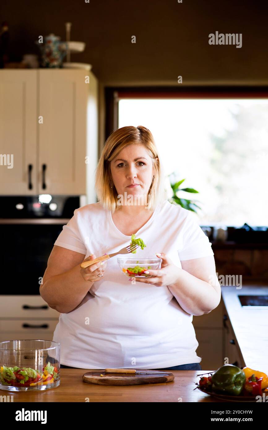 Portrait of beautiful young overweight woman choosing healthy food ...
